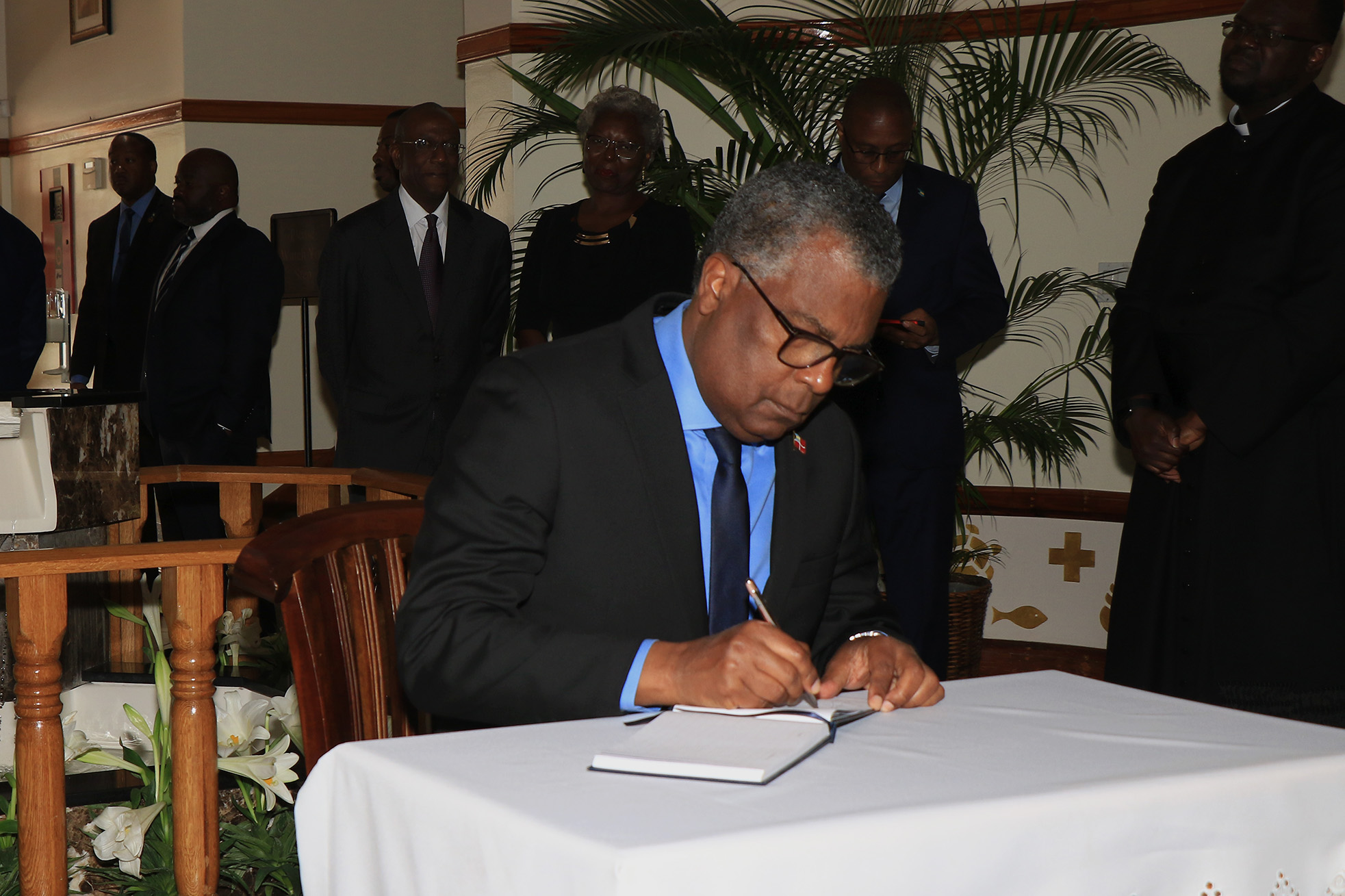 Minister of Foreign Affairs Fred Mitchell signs the Book of Condolence ...